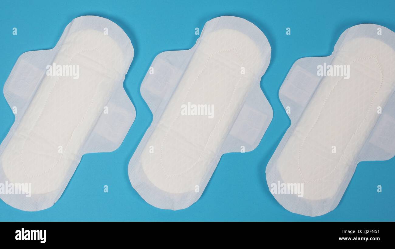 Woman sanitary napkins on blue background. Top view. Absorbent pads ...