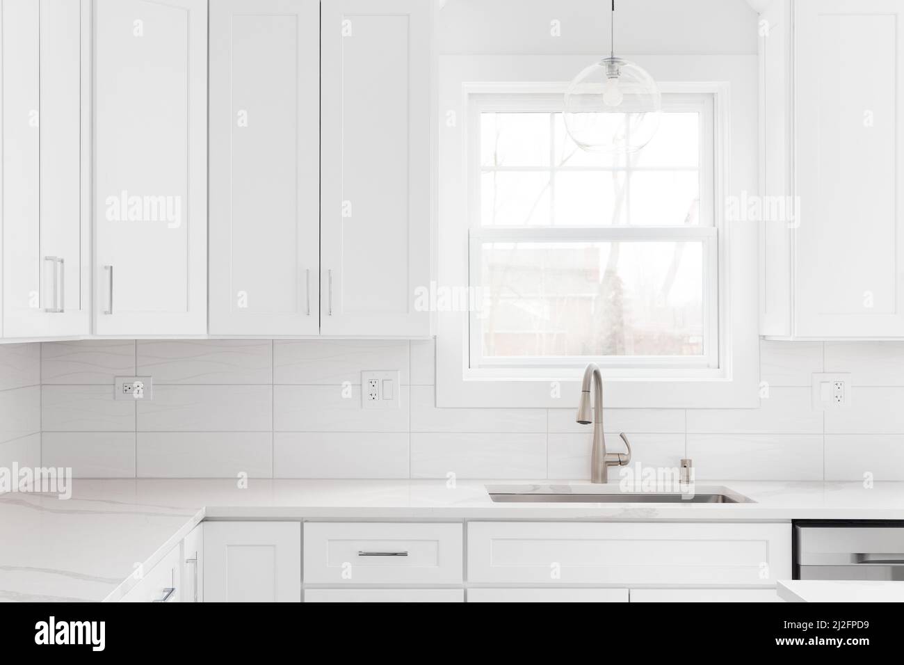 A kitchen detail shot with white cabinets, wavy subway tile backsplash ...