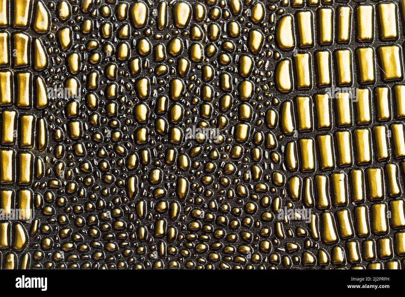 A texture of a golden plastic cloth with bubbles in a close up view ...
