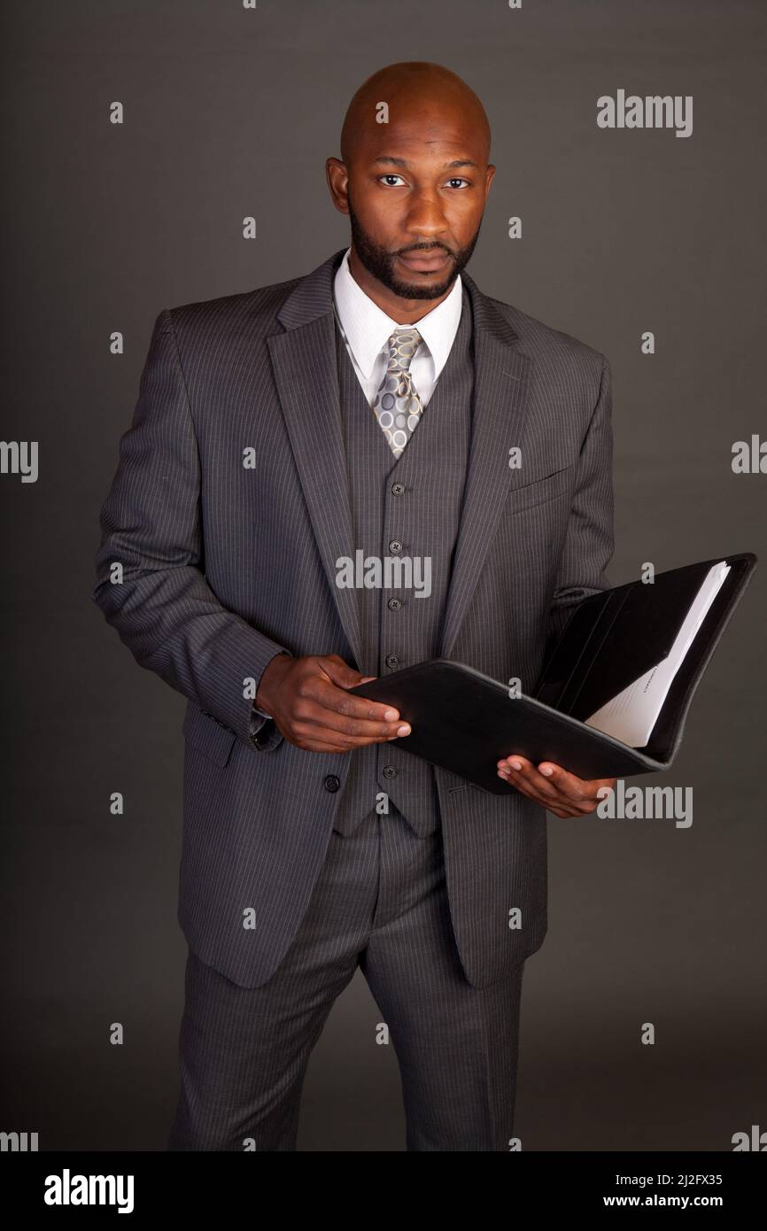 Young black business man holding a portfolio Stock Photo - Alamy