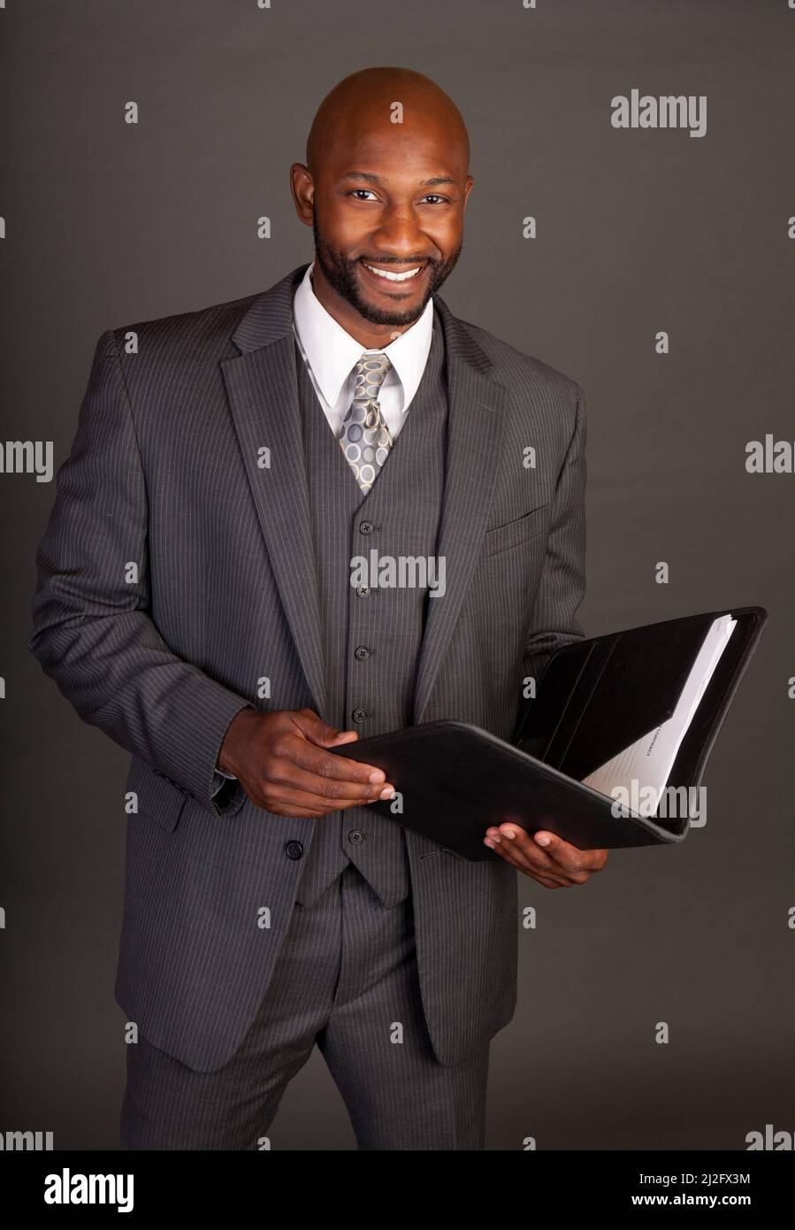 Young black business man holding a portfolio Stock Photo - Alamy