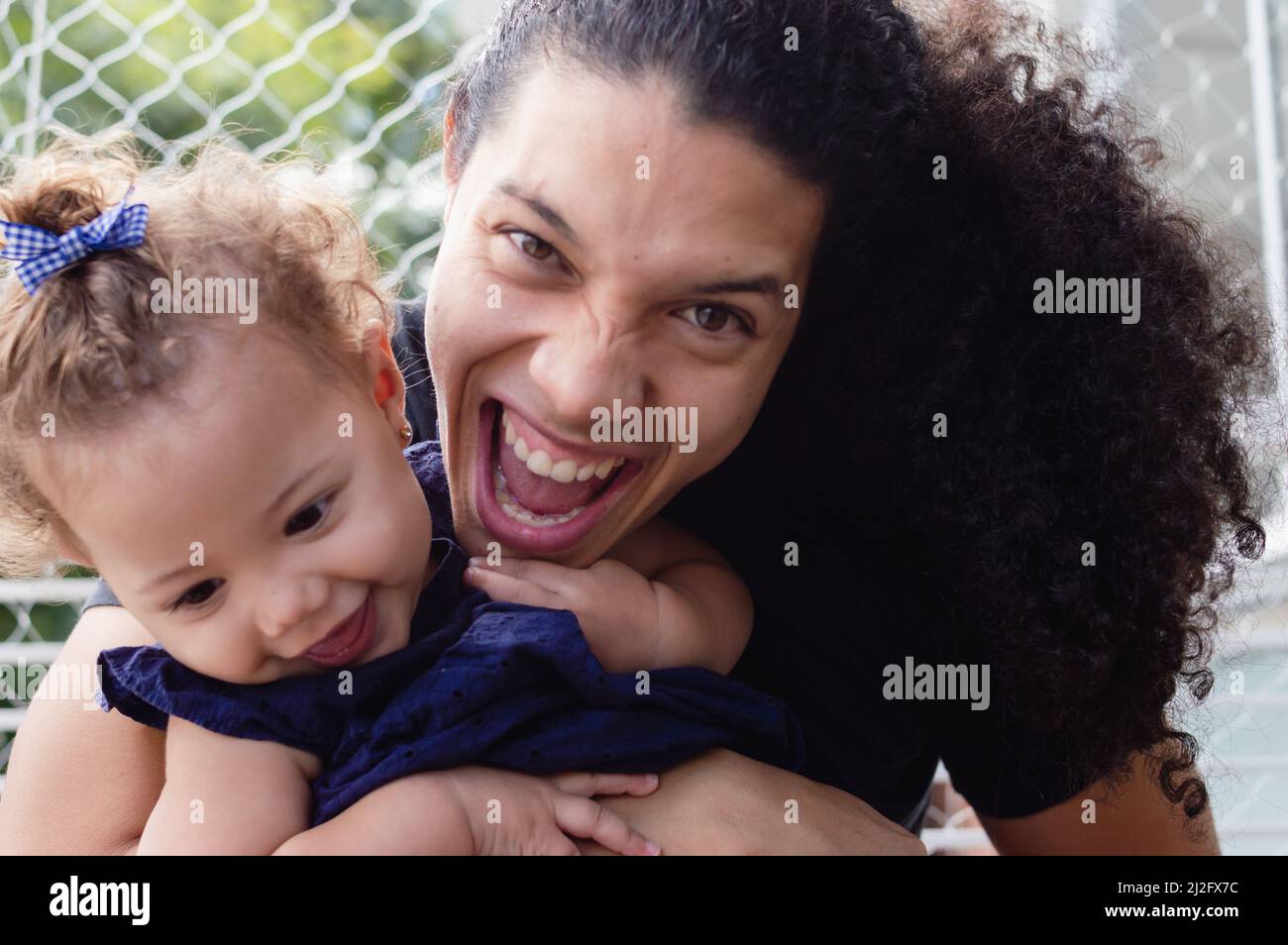 closeup of young caucasian father with long curly hair, looking at the ...
