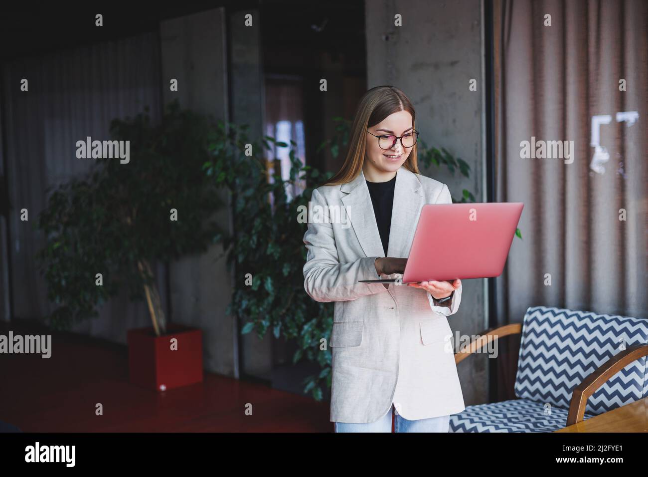 Female administrative manager in glasses and formal suit walking to ...