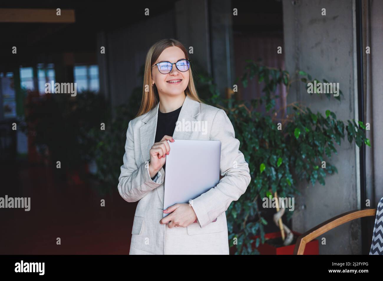 Portrait of a successful manager in the office smiling in during the ...