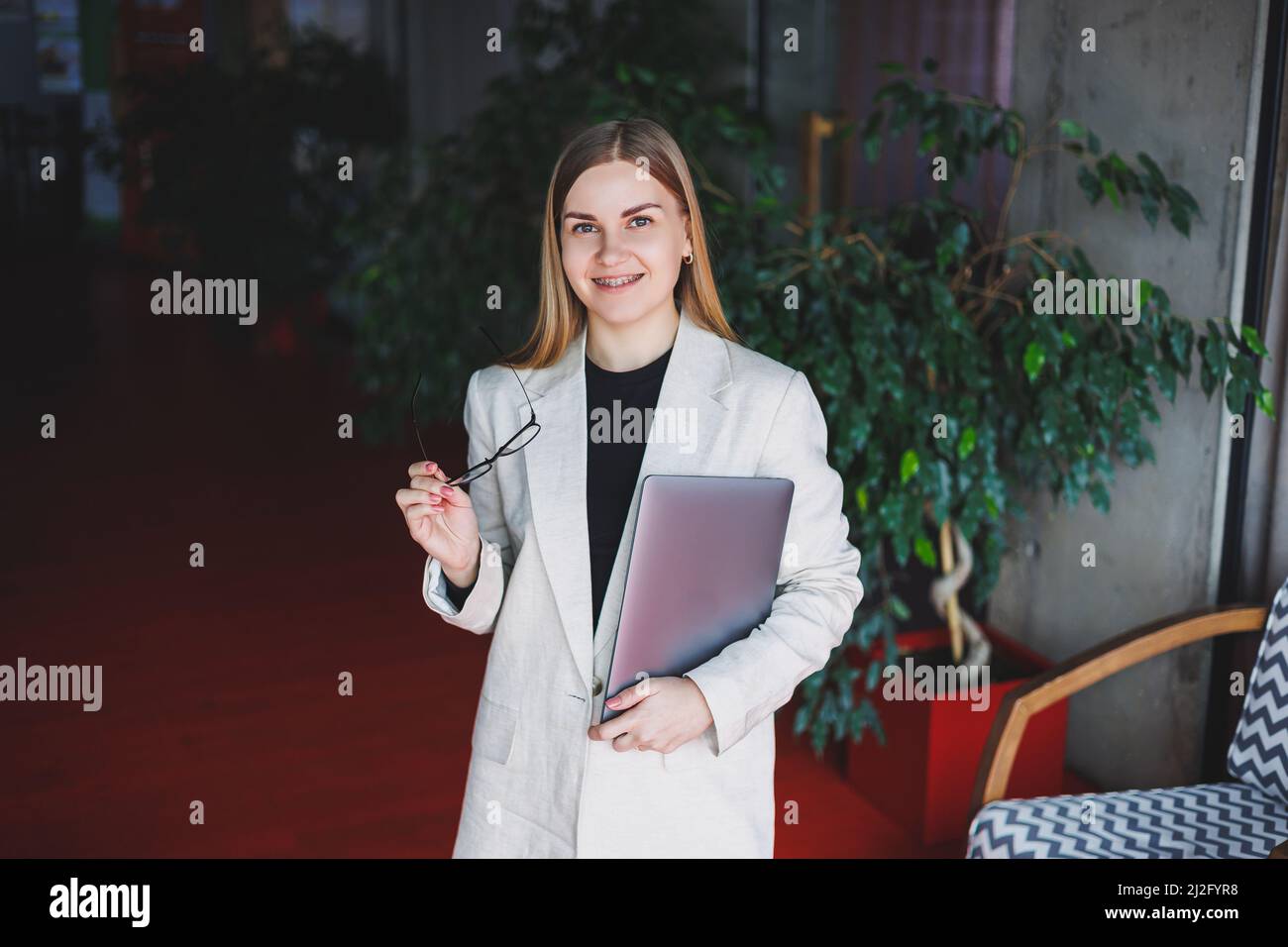 Portrait of a successful manager in the office smiling in during the ...