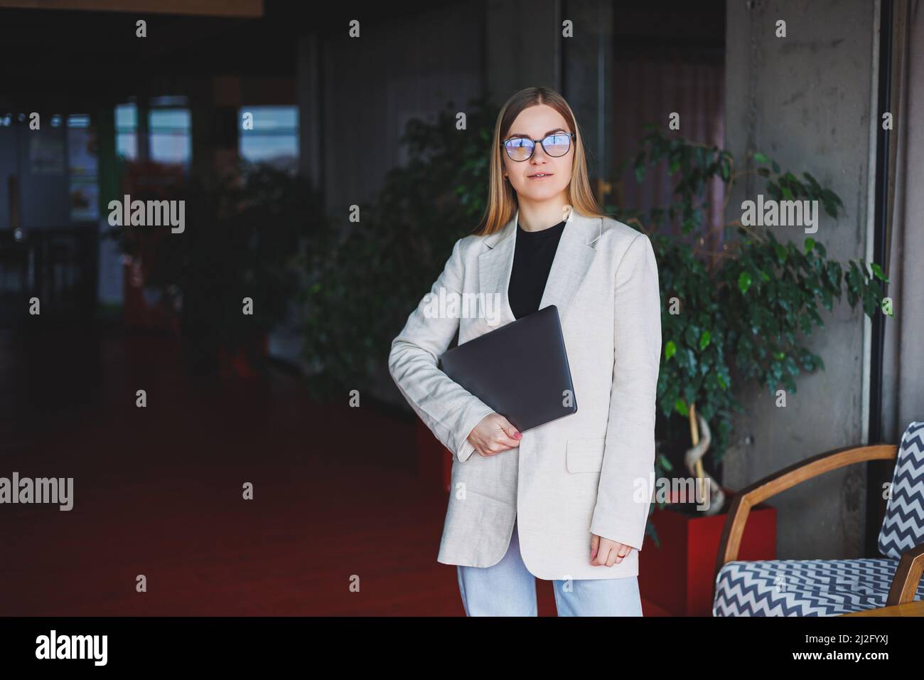 Portrait of a successful manager in the office smiling in during the ...