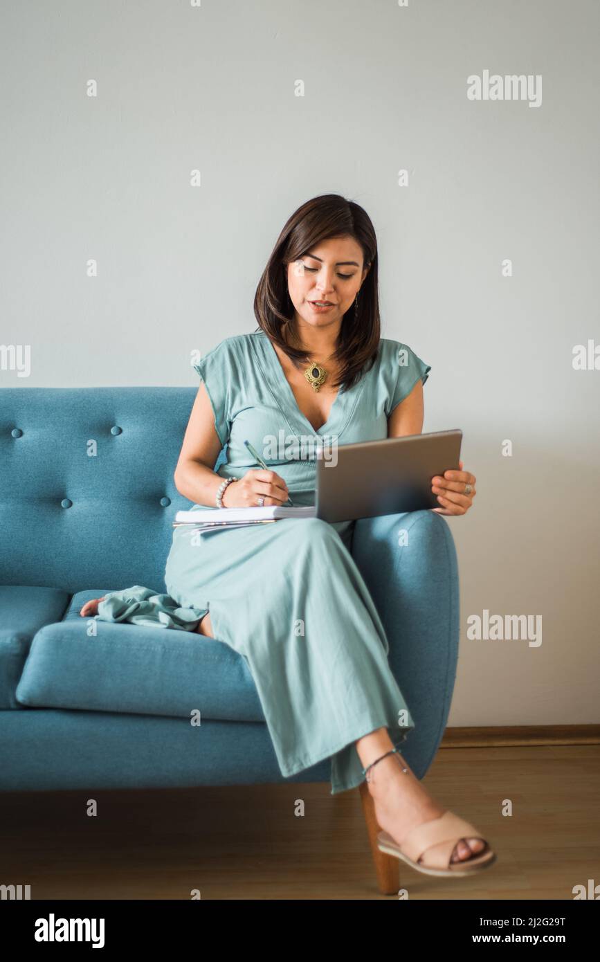 Vertical image of a psychologist taking notes on a video call from home ...