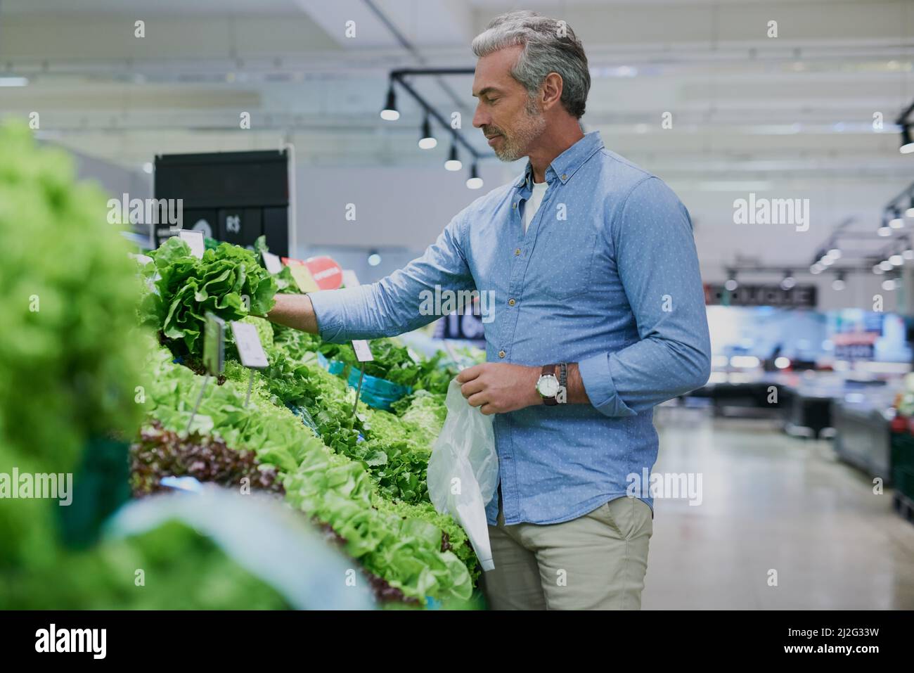 Making the grocery run a healthy one. Shot of a handsome mature man ...