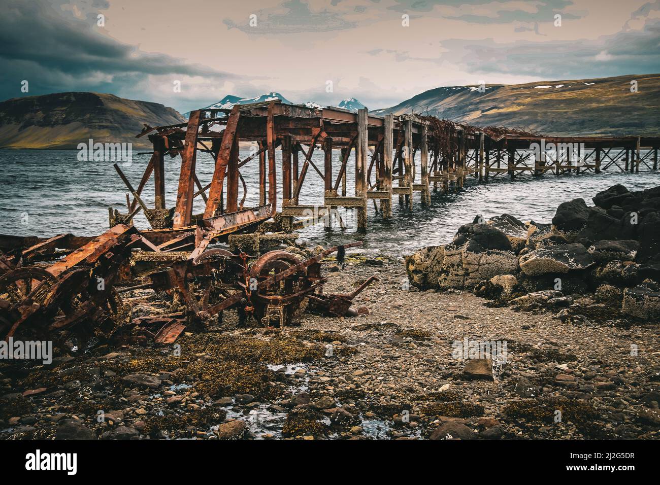 An old damaged bridge over the water in Iceland on cloudy sky ...