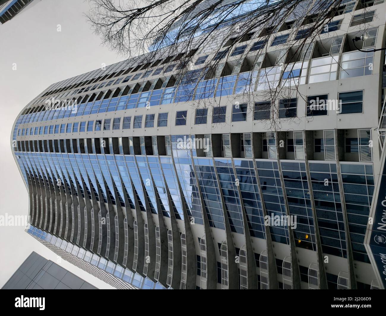 A vertical low angle shot of a modern building with glass windows Stock ...