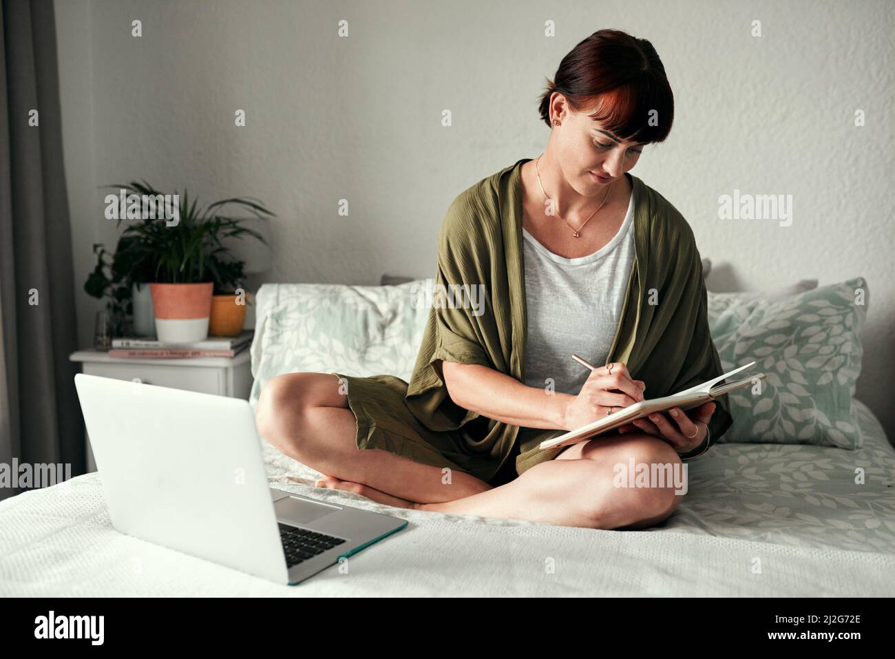 Dear diary.... Full length shot of an attractive young woman writing ...