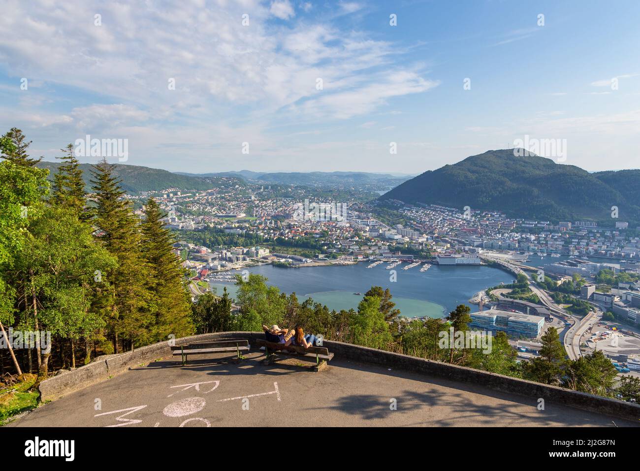 Bergen, Norway - 28 May 2018: People sitting on a bench on Floyen Hill. View of the city and the ...