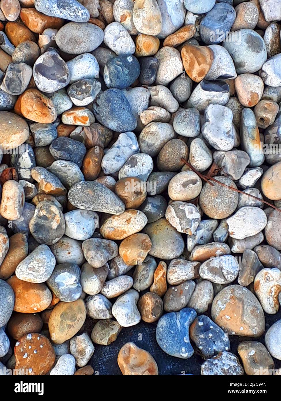 Multi coloured pebbles in a garden patio area.This is a weed retardant ...