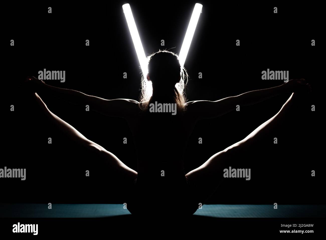 Fit woman practicing yoga poses. Silhouette girl doing exercise in ...