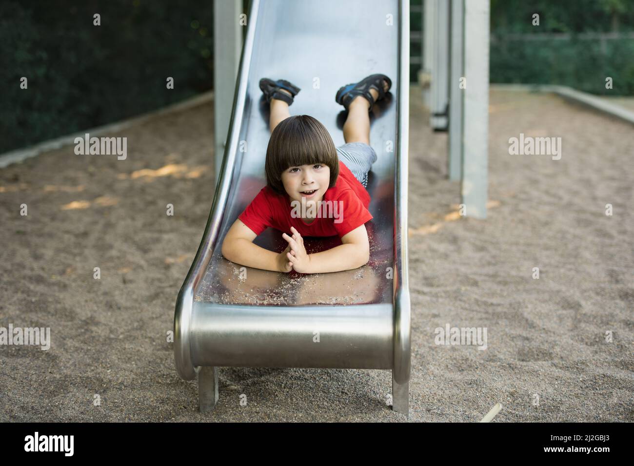 Child slides down on playground, outdoor activity Stock Photo - Alamy