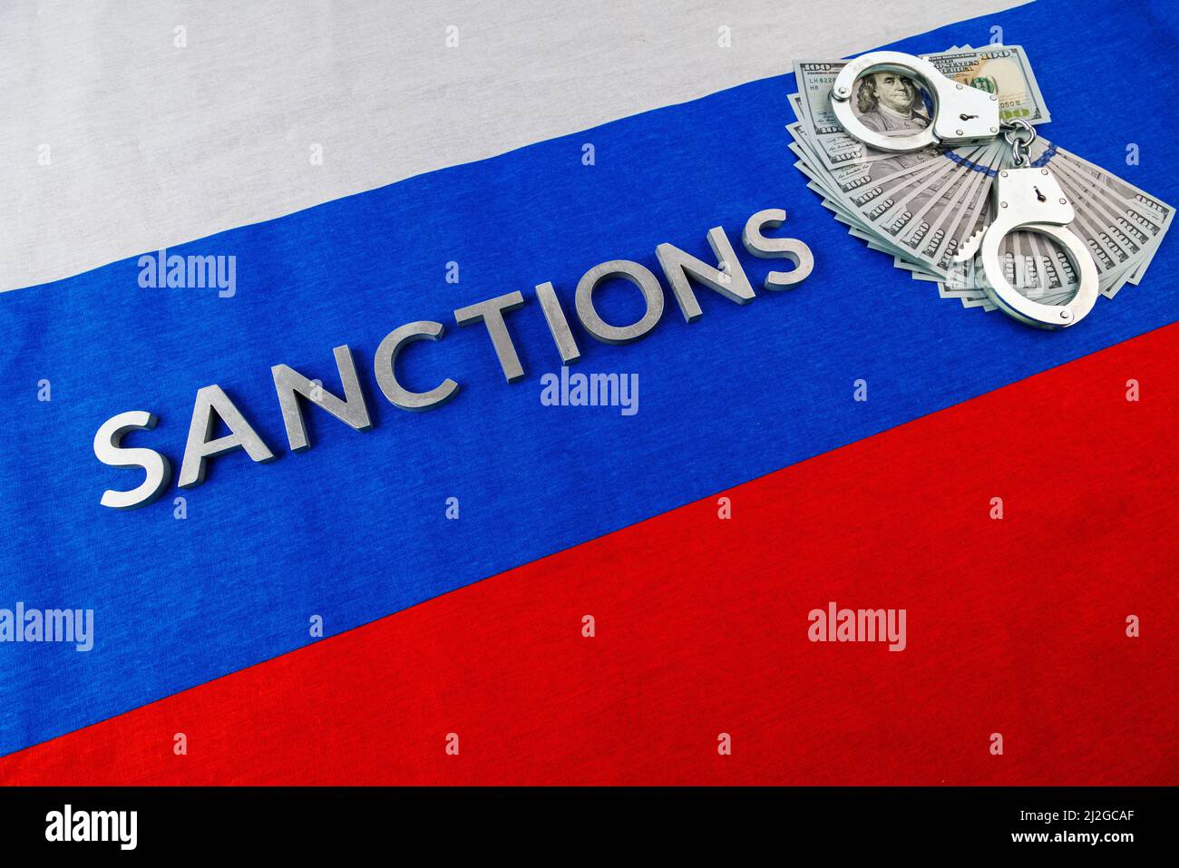 the word sanctions laid with silver metal letters on russian tricolor ...