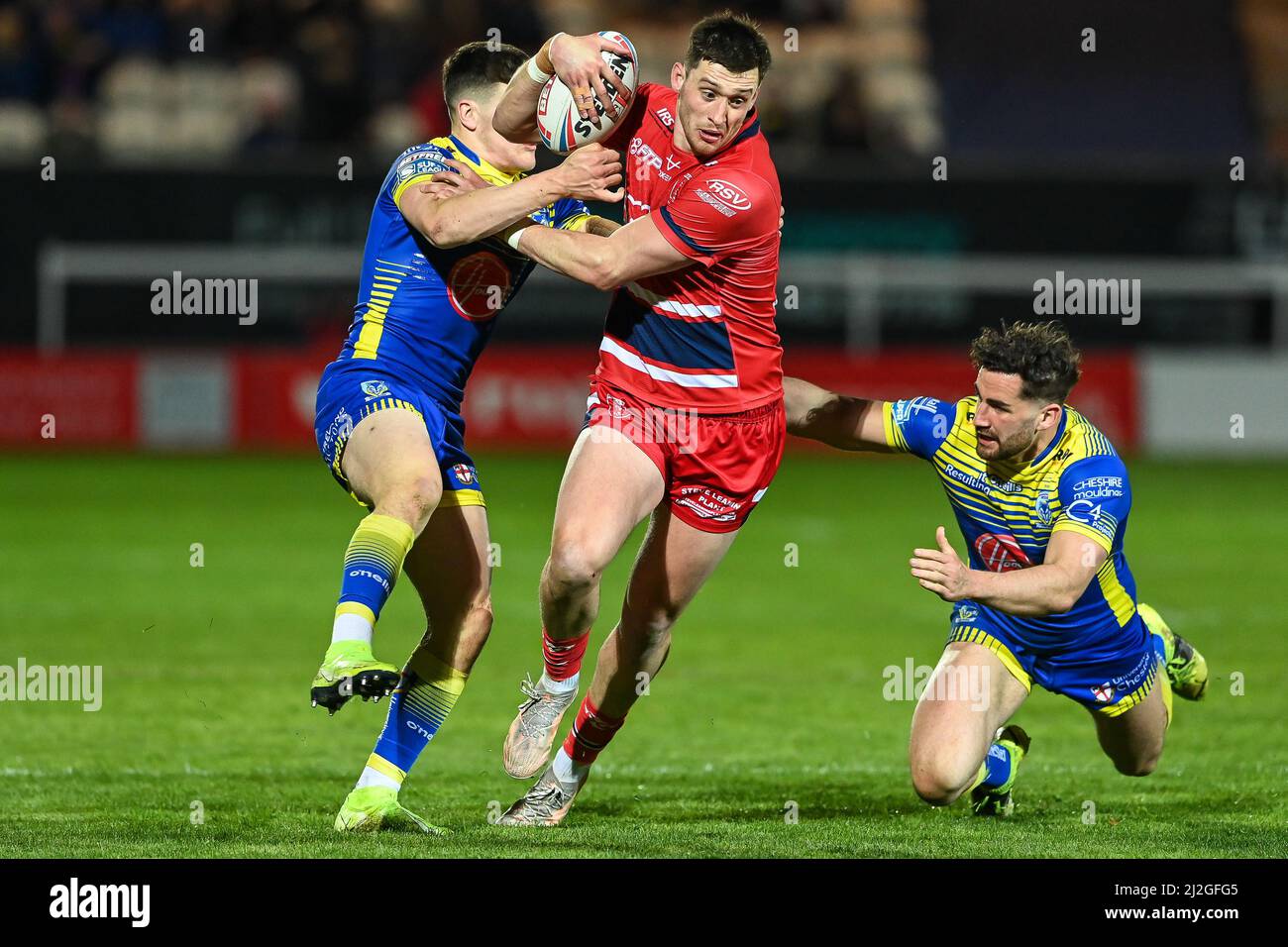Sam Wood #24 of Hull KR evades the tackle of Josh Thewlis #22 and Toby ...
