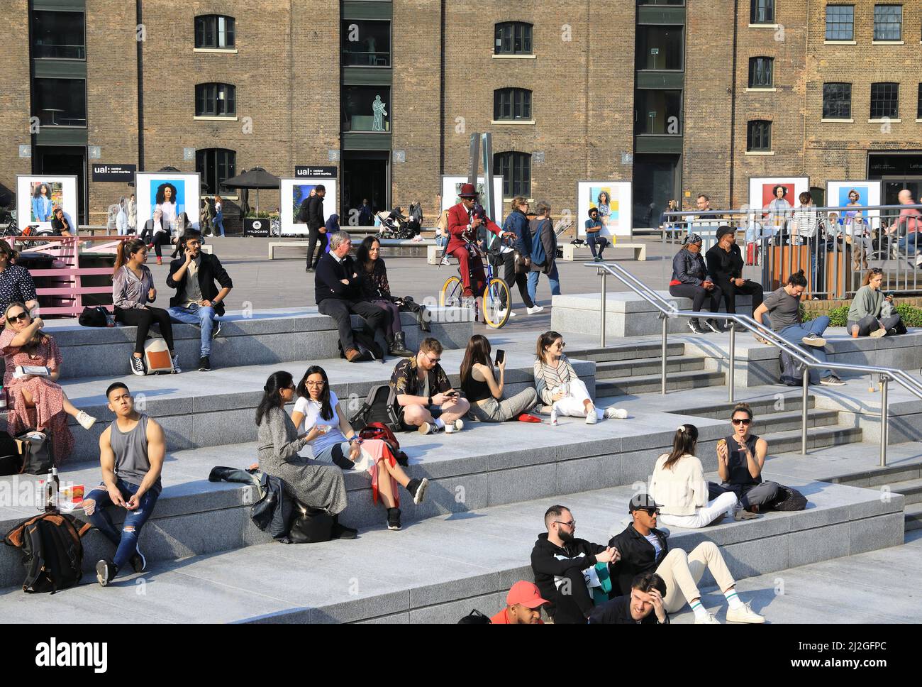 People enjoying early spring sunshine on the steps of Granary Square ...