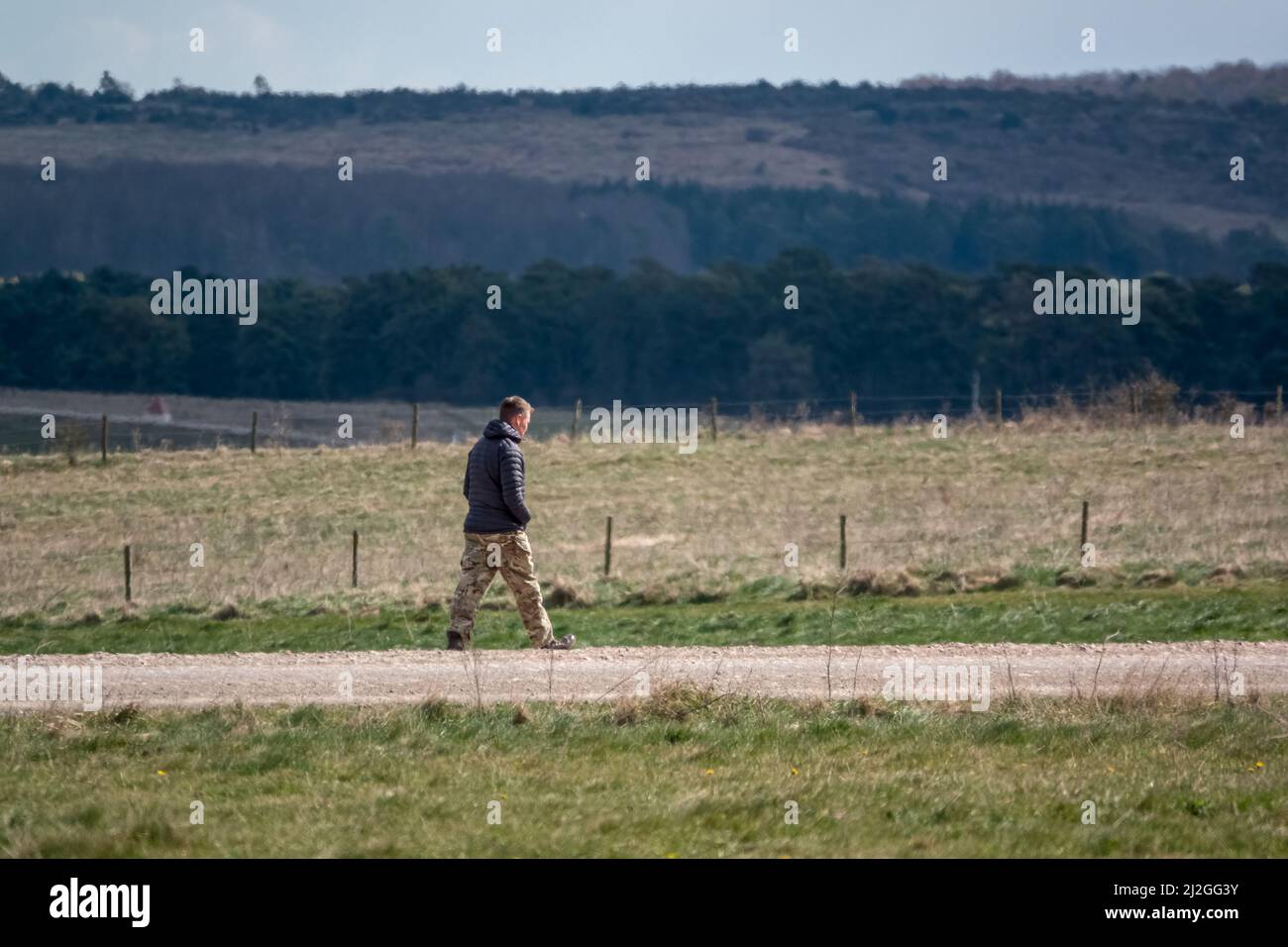 man walking at speed along an unmade track road, hiking, fitness Stock ...