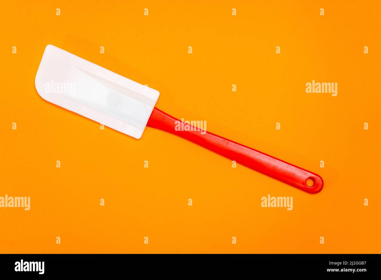 Red and white kitchen spatula made of silicone and plastic insulated on ...