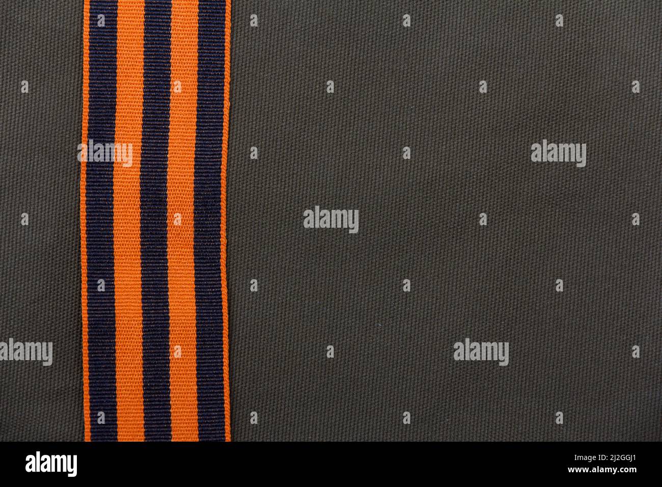 St. George's ribbon on a green fabric background. Isolated St. George ...