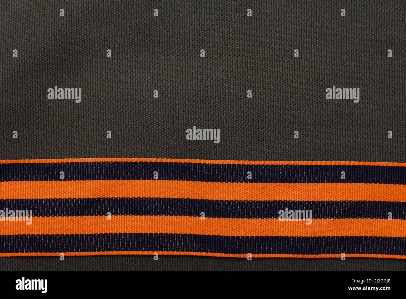 St. George's ribbon on a green fabric background. Isolated St. George ...