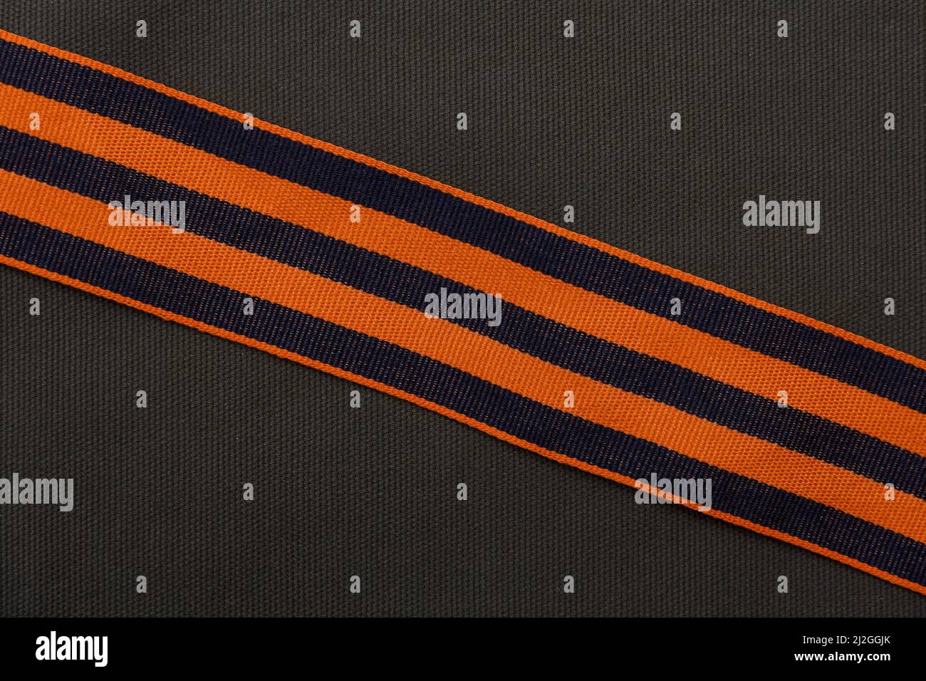 St. George's ribbon on a green fabric background. Isolated St. George ...