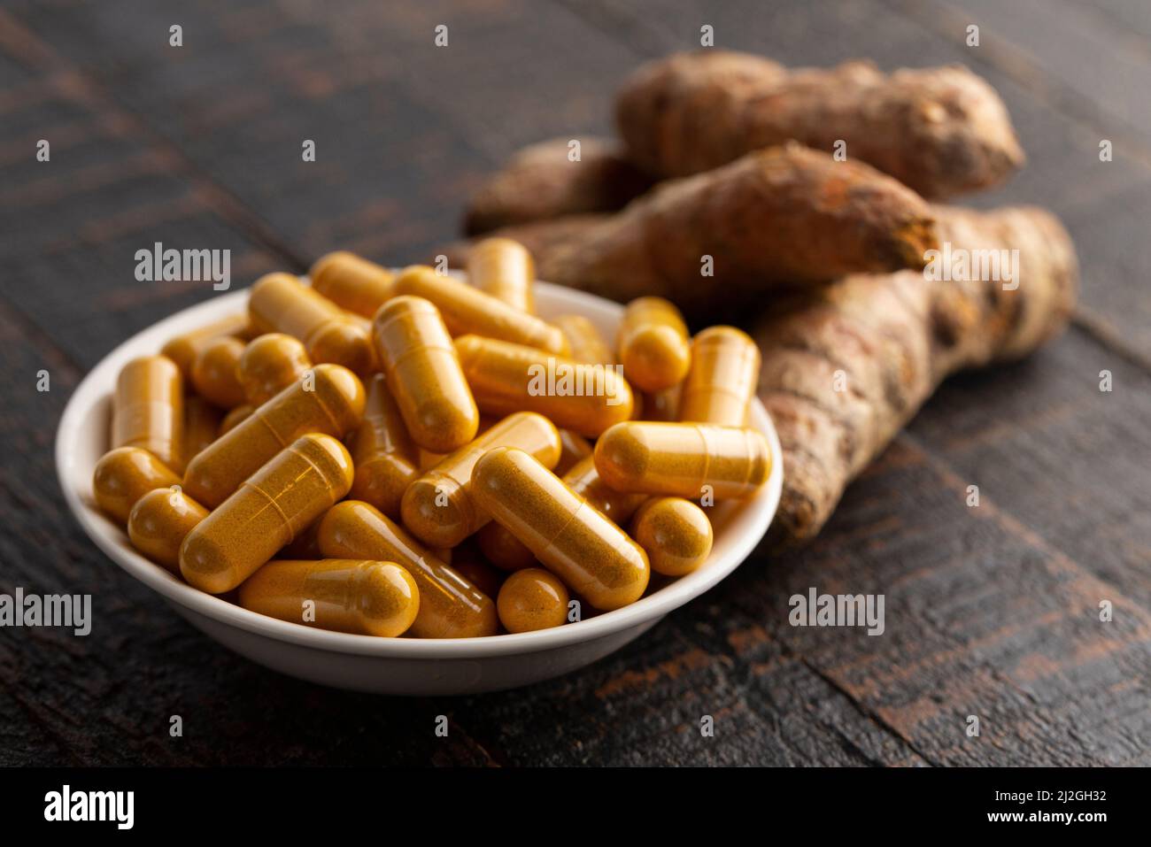 Ground Turmeric Capsules form on a Dark Wooden Table Stock Photo - Alamy