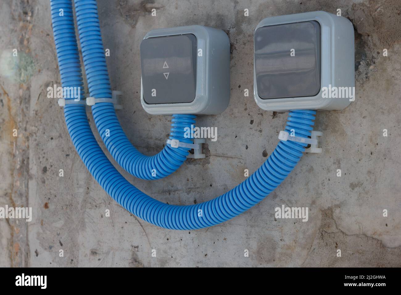Industrial Electric Switches with protected cable on a concrete wall ...