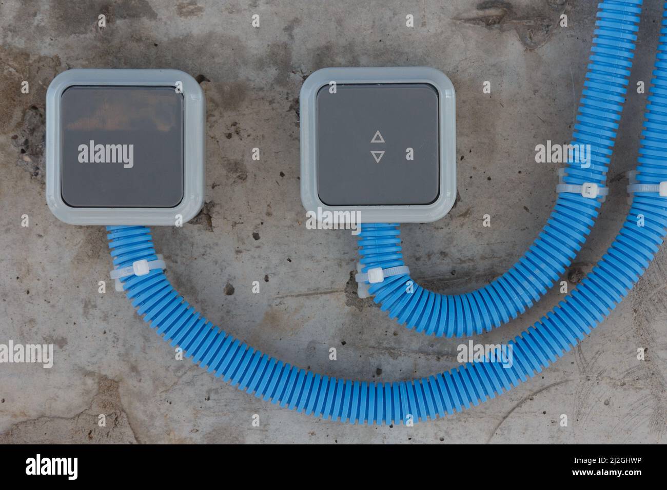 Industrial Electric Switches with protected cable on a concrete wall ...