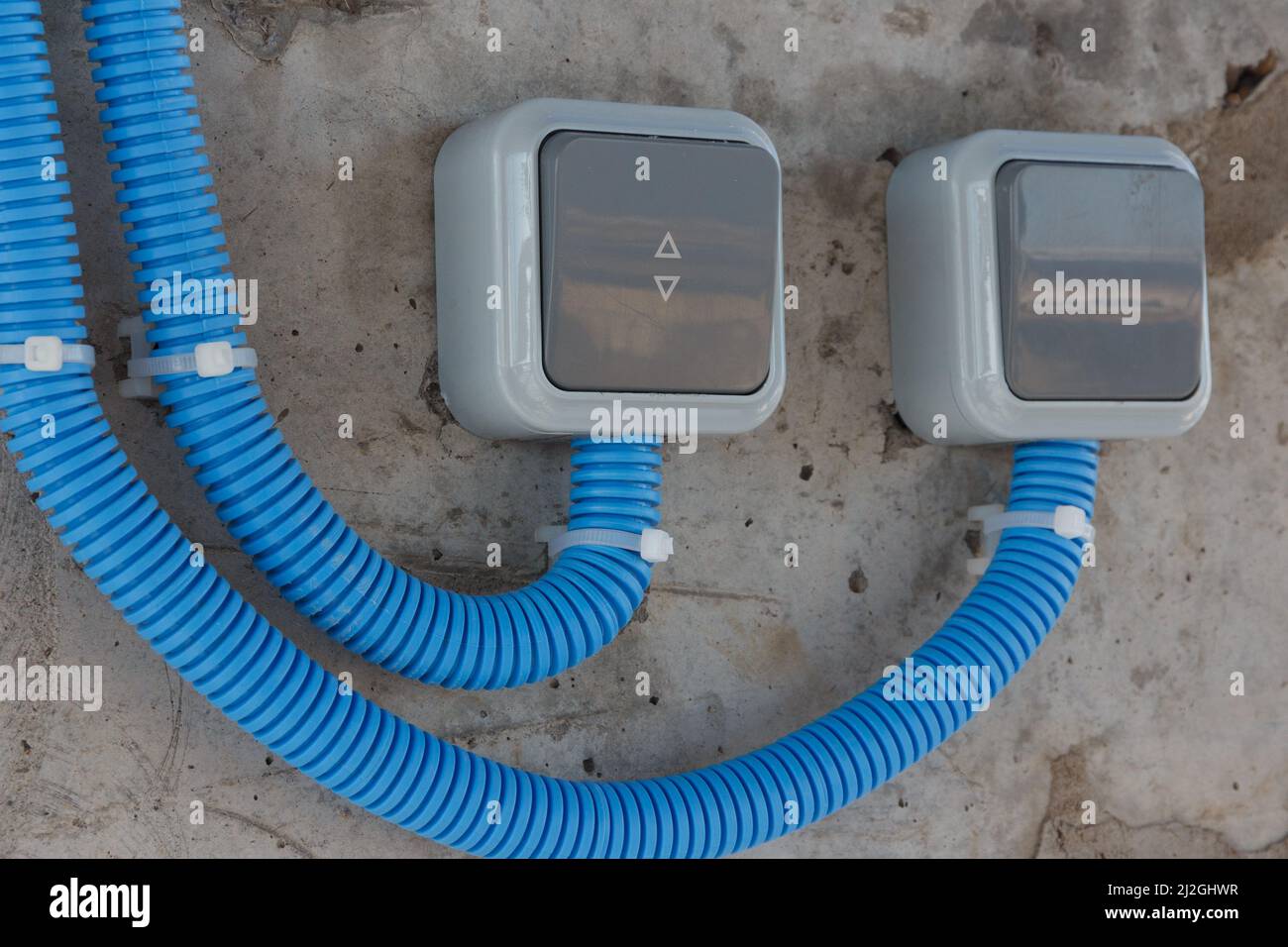 Industrial Electric Switches with protected cable on a concrete wall ...