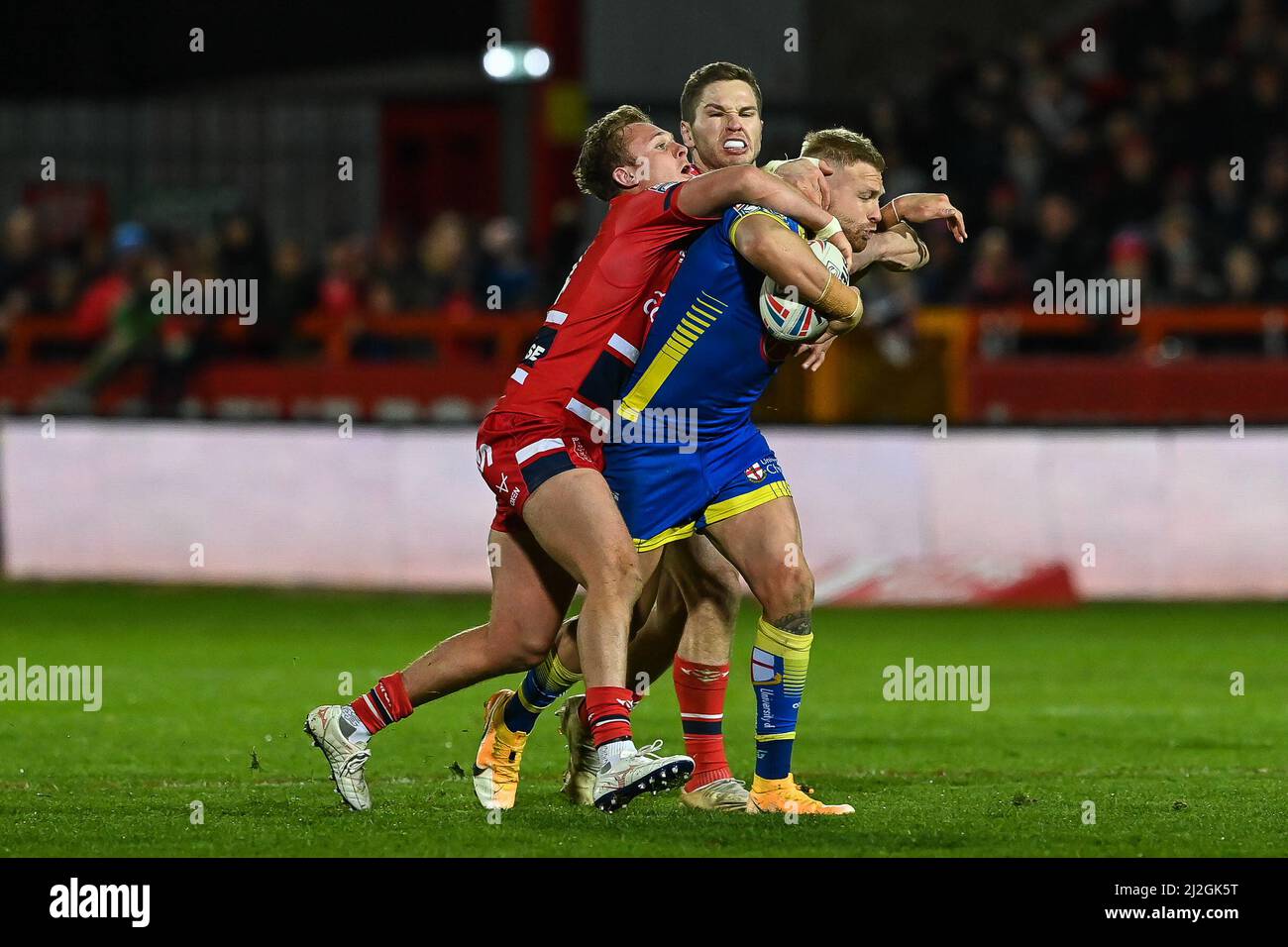 Oliver Holmes #12 of Warrington Wolves is tackled by Matt Parcell #9 of ...