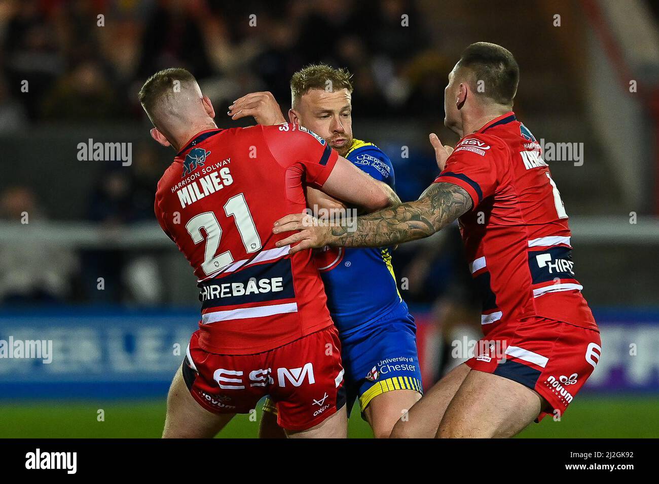 Oliver Holmes #12 of Warrington Wolves is tackled by Rowan Milnes #21 ...