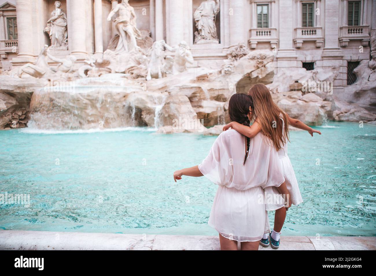 Mother and daughter enjoy the Trevi Fountain, Rome, Italy. Happy family ...