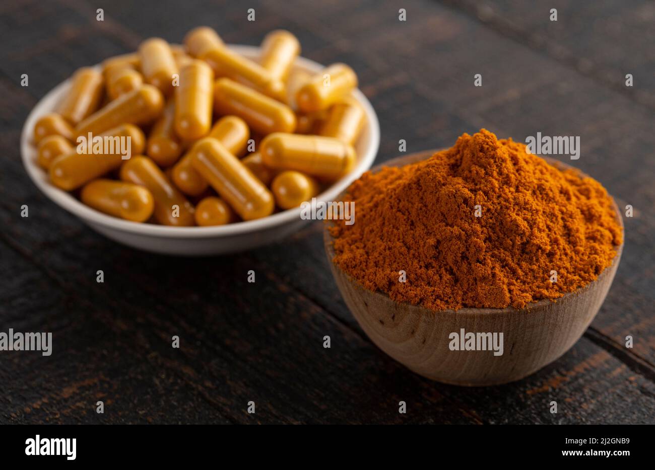 Ground Turmeric Capsules form on a Dark Wooden Table Stock Photo - Alamy