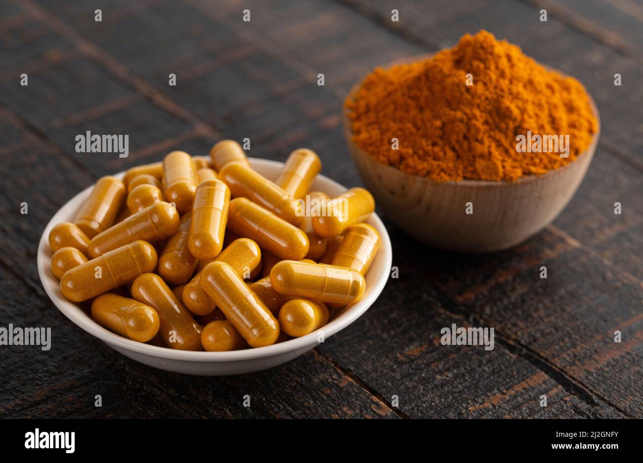 Ground Turmeric Capsules form on a Dark Wooden Table Stock Photo - Alamy