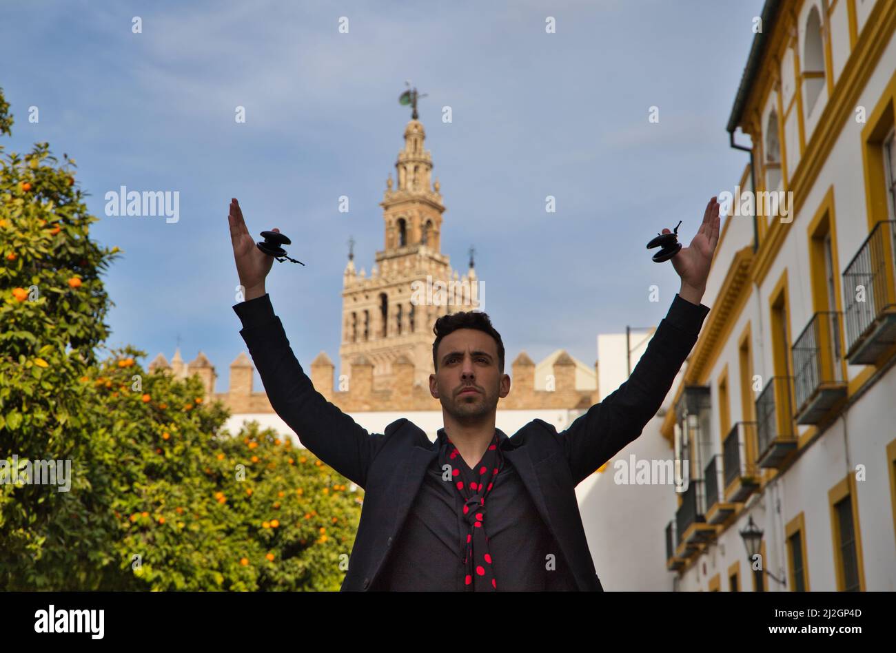 A gypsy man dancing flamenco, dressed in black with castanets posing ...