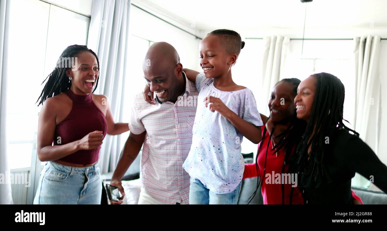 African family celebrating success cheering holding cellphone device ...