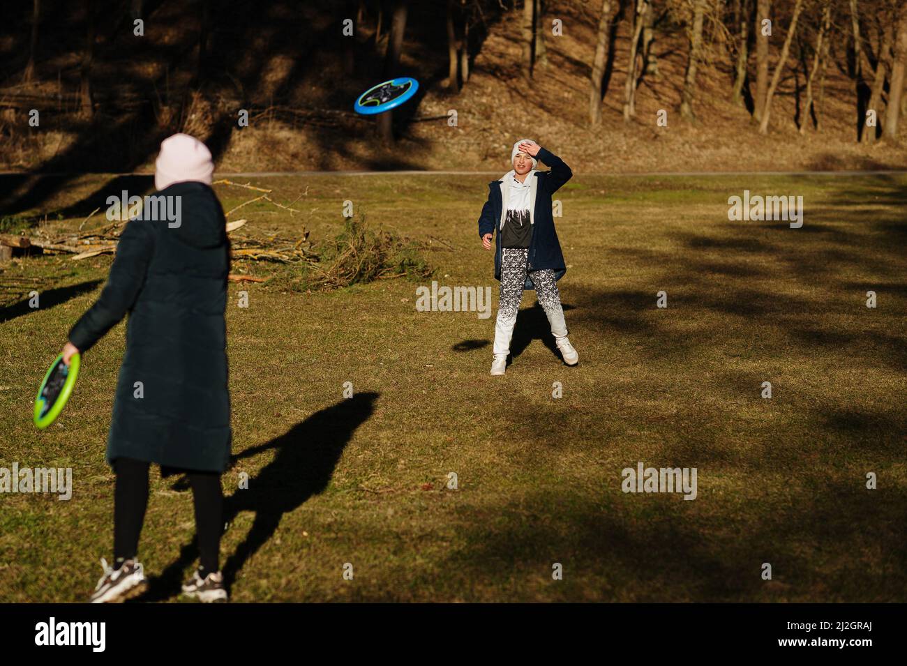 Two kids playing with disc frisbee on a green meadow gras Stock Photo ...