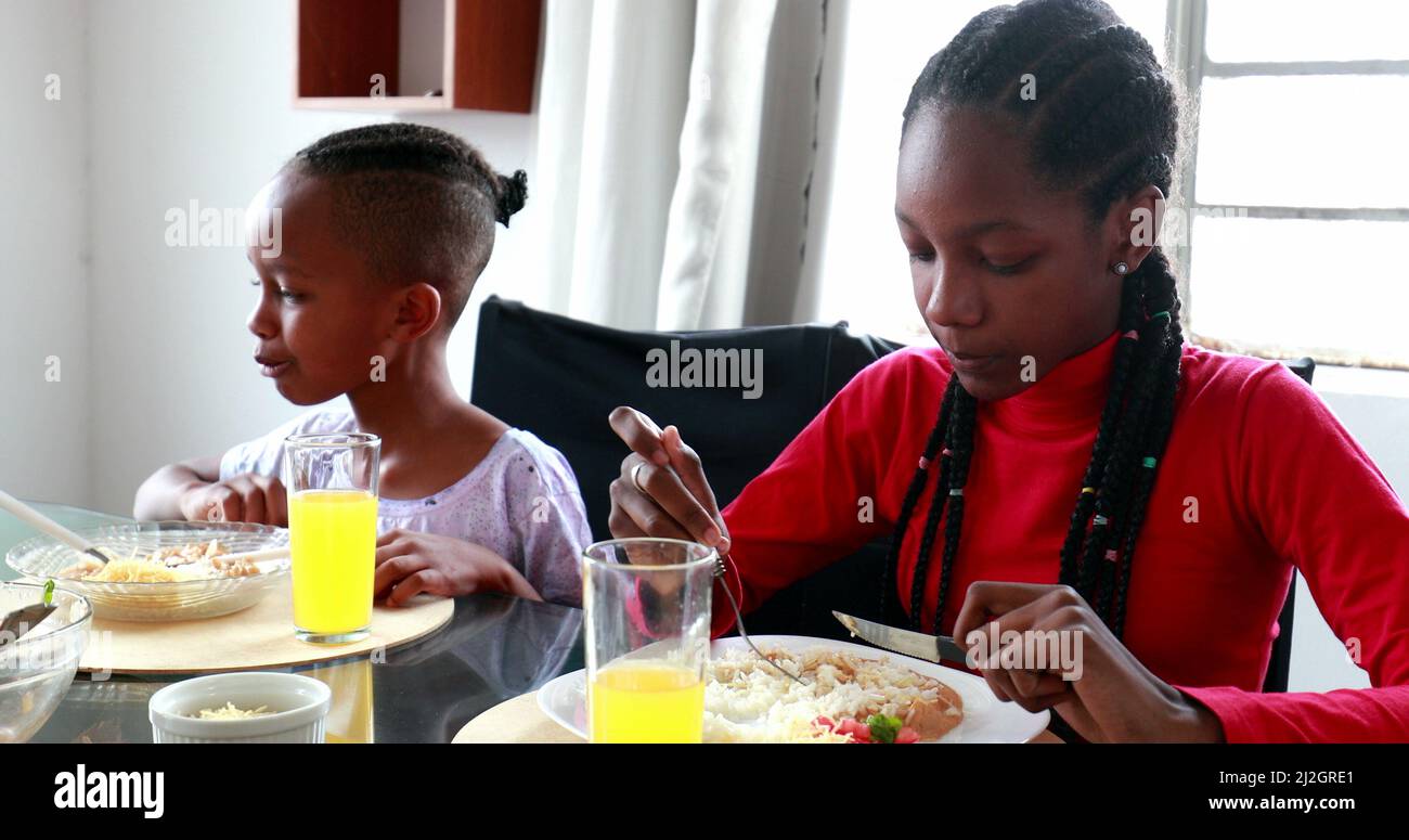 Black African family eating lunch together, father and children ...