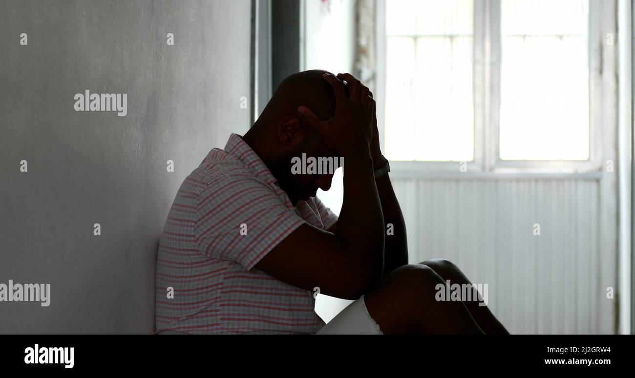 Desperate black man sitting hi-res stock photography and images - Alamy