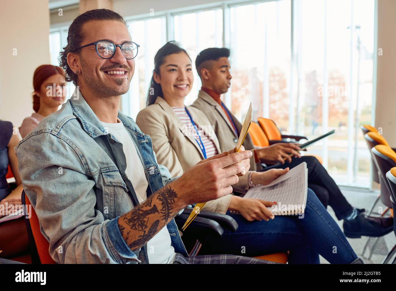 Young participants are enjoying while following a business lecture in a ...
