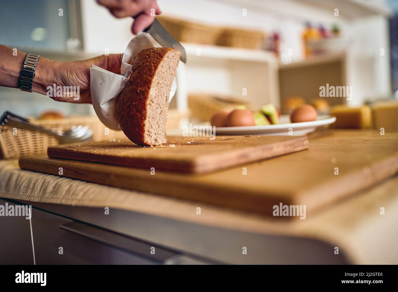 A man is cutting the bread in a pleasant atmosphere in the kitchen ...