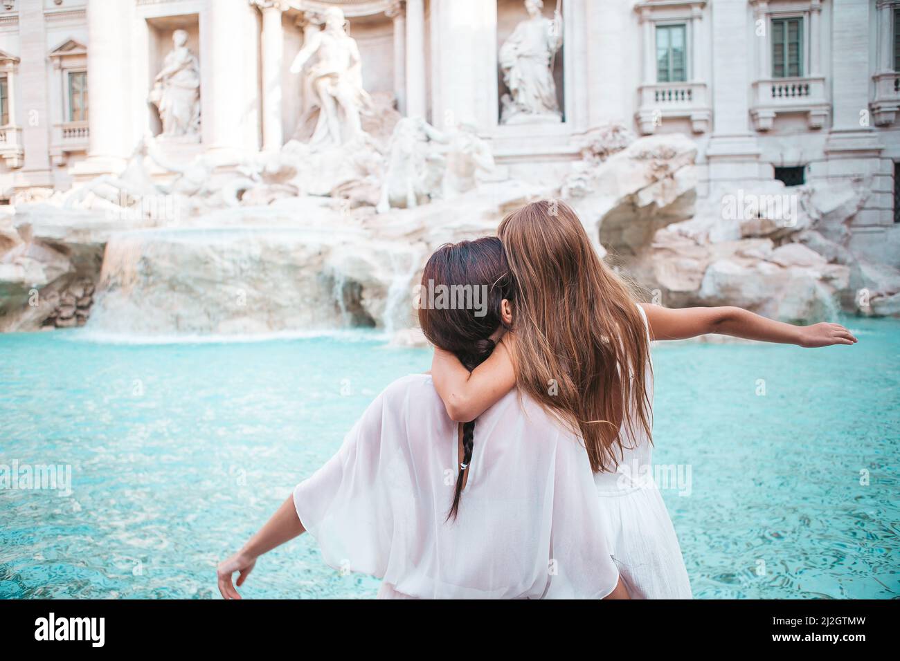 Mother and daughter enjoy the Trevi Fountain, Rome, Italy. Happy family ...