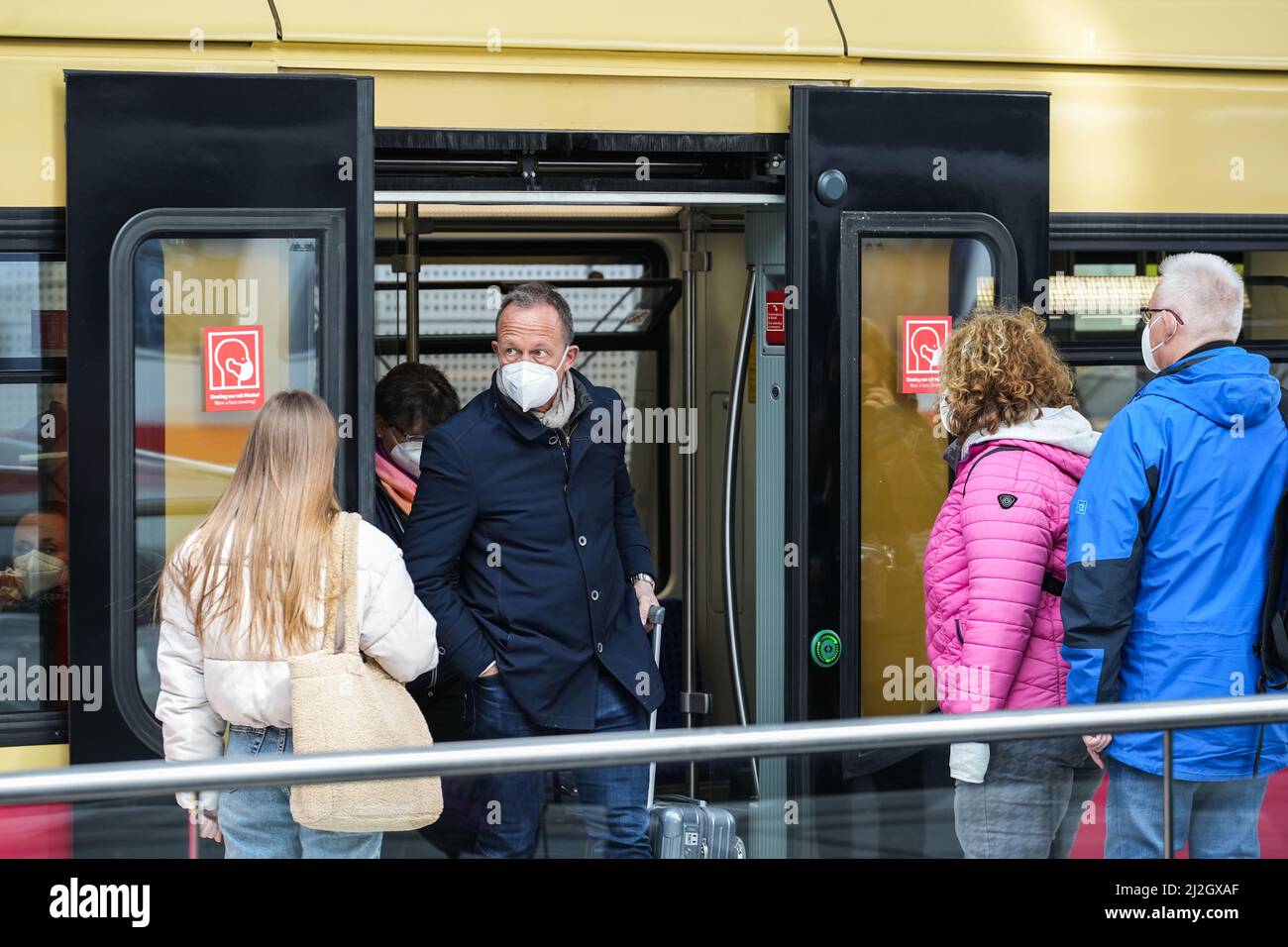 Berlin, Germany. 1st Apr, 2022. A passenger wearing a face mask gets ...