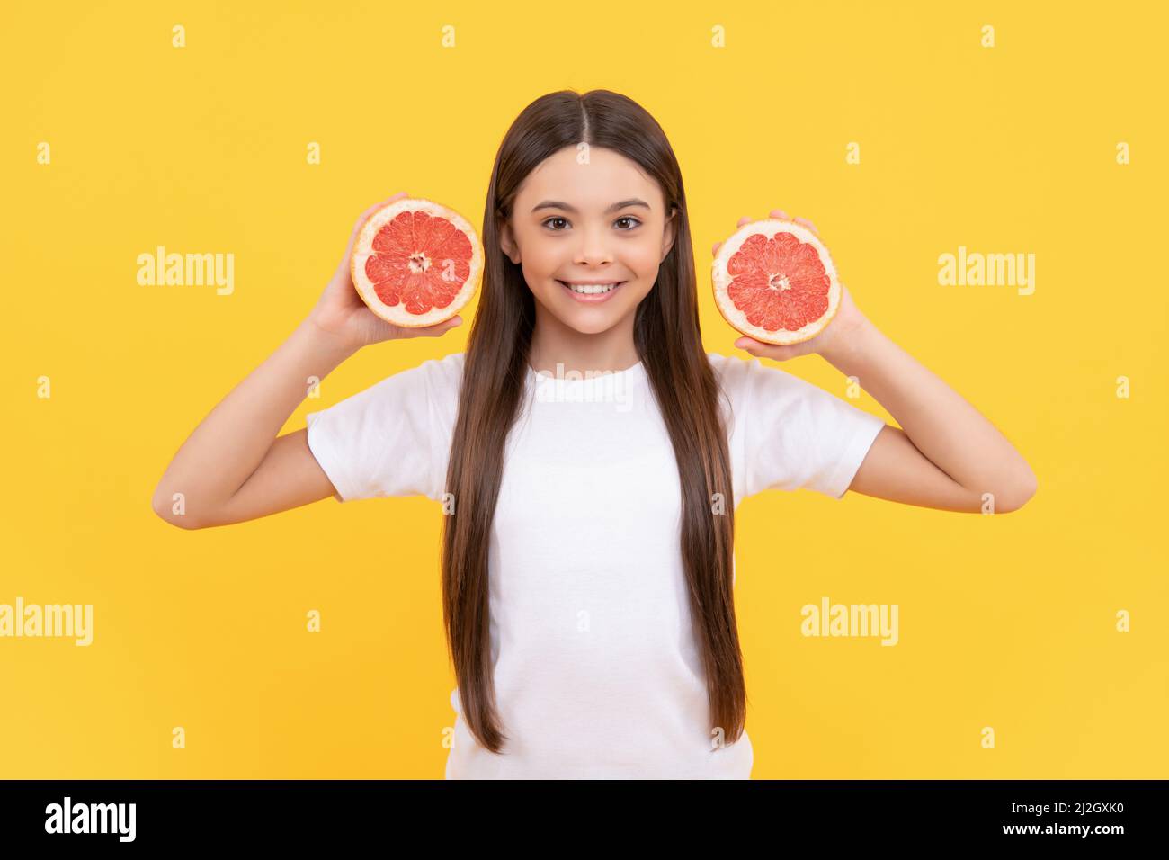 glad teen girl with grapefruit. vitamin and dieting. child eating ...