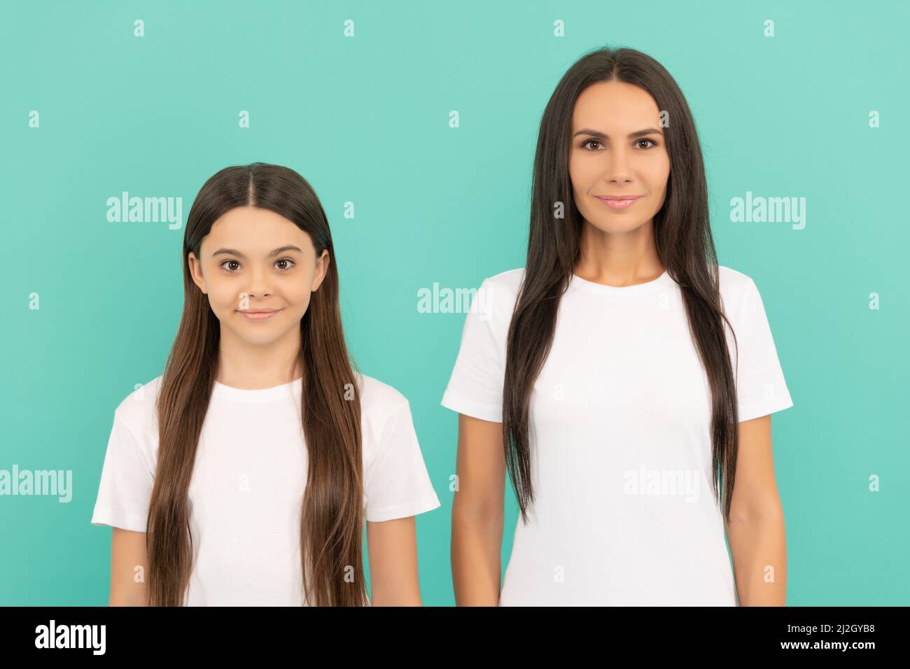 mother and daughter with long hair on blue background Stock Photo - Alamy