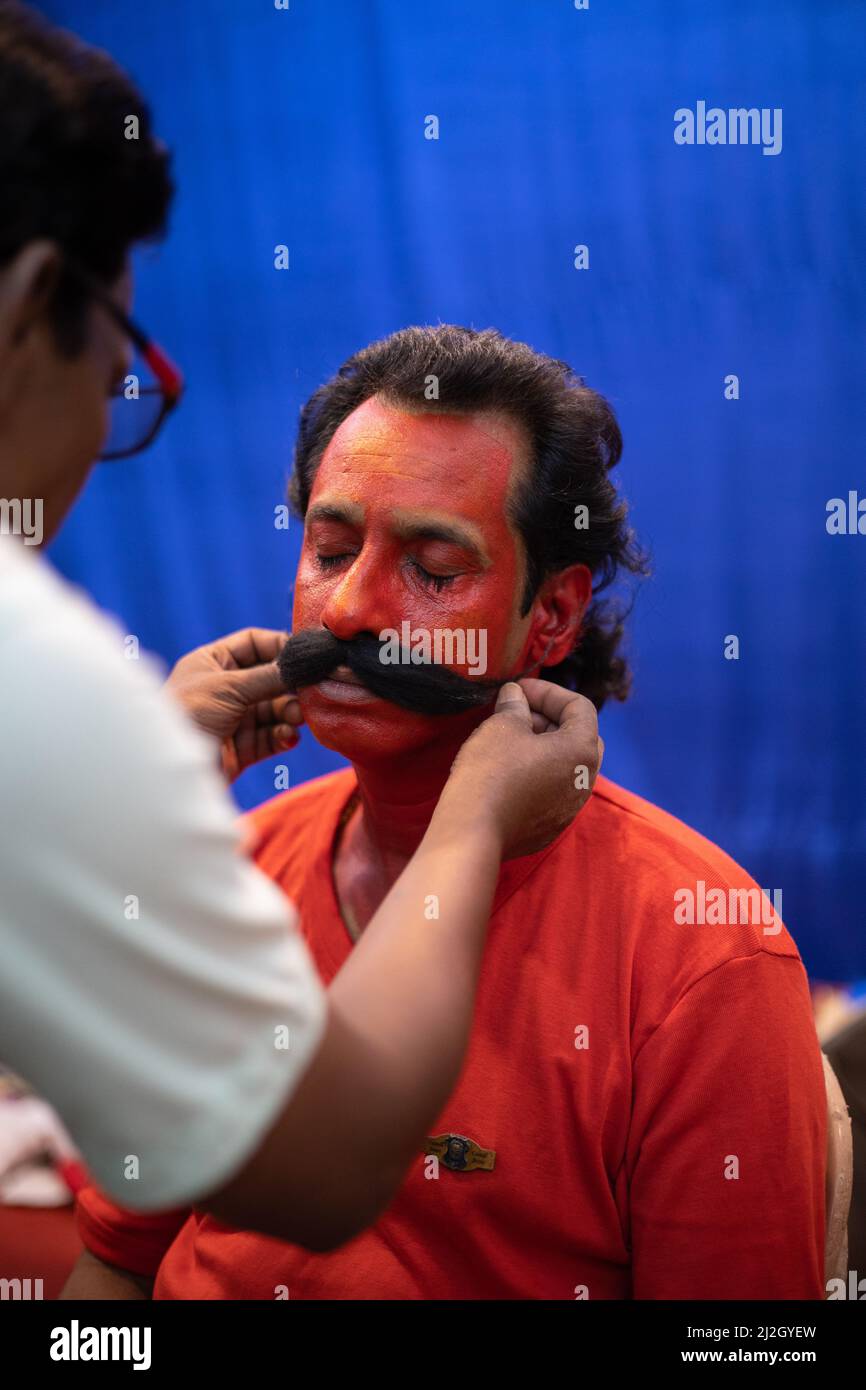 Face makeover artist attaching fake moustache to face of man supposed ...