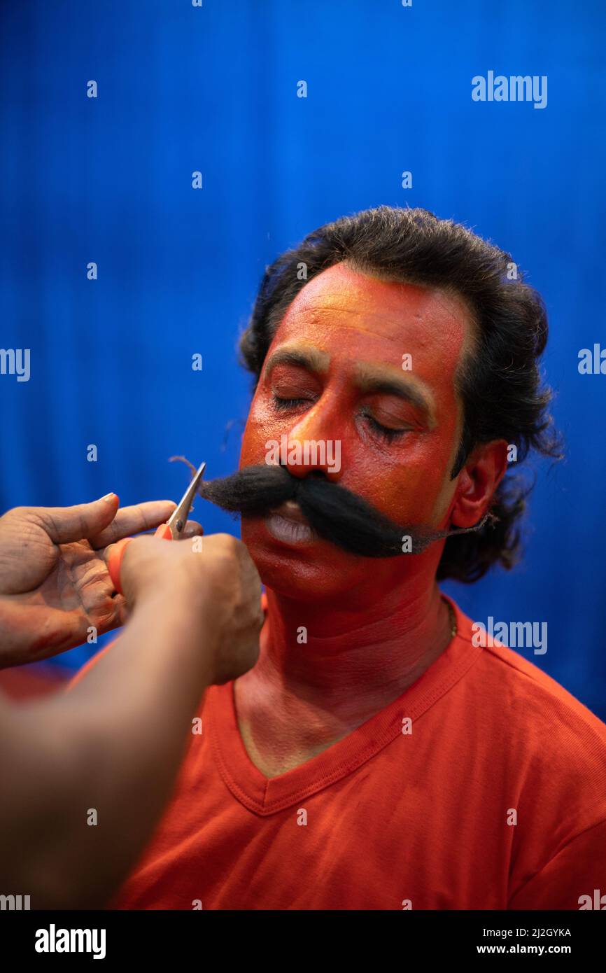 Face makeover artist attaching fake moustache to face of man supposed ...