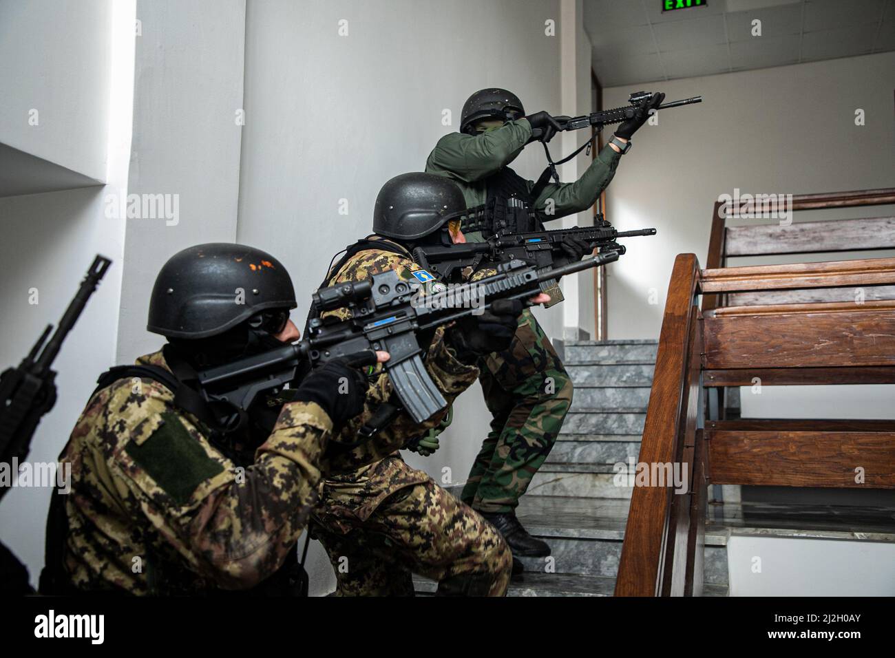 Four members of Kosovo Special Intervention Unit proceed up stairs to ...